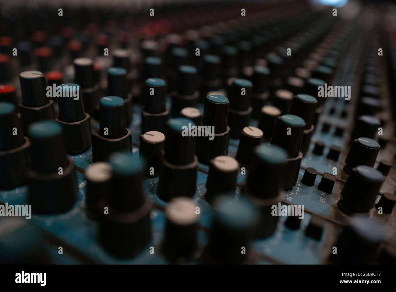 Control knobs of an audio mixing console are prominently displayed in a ...