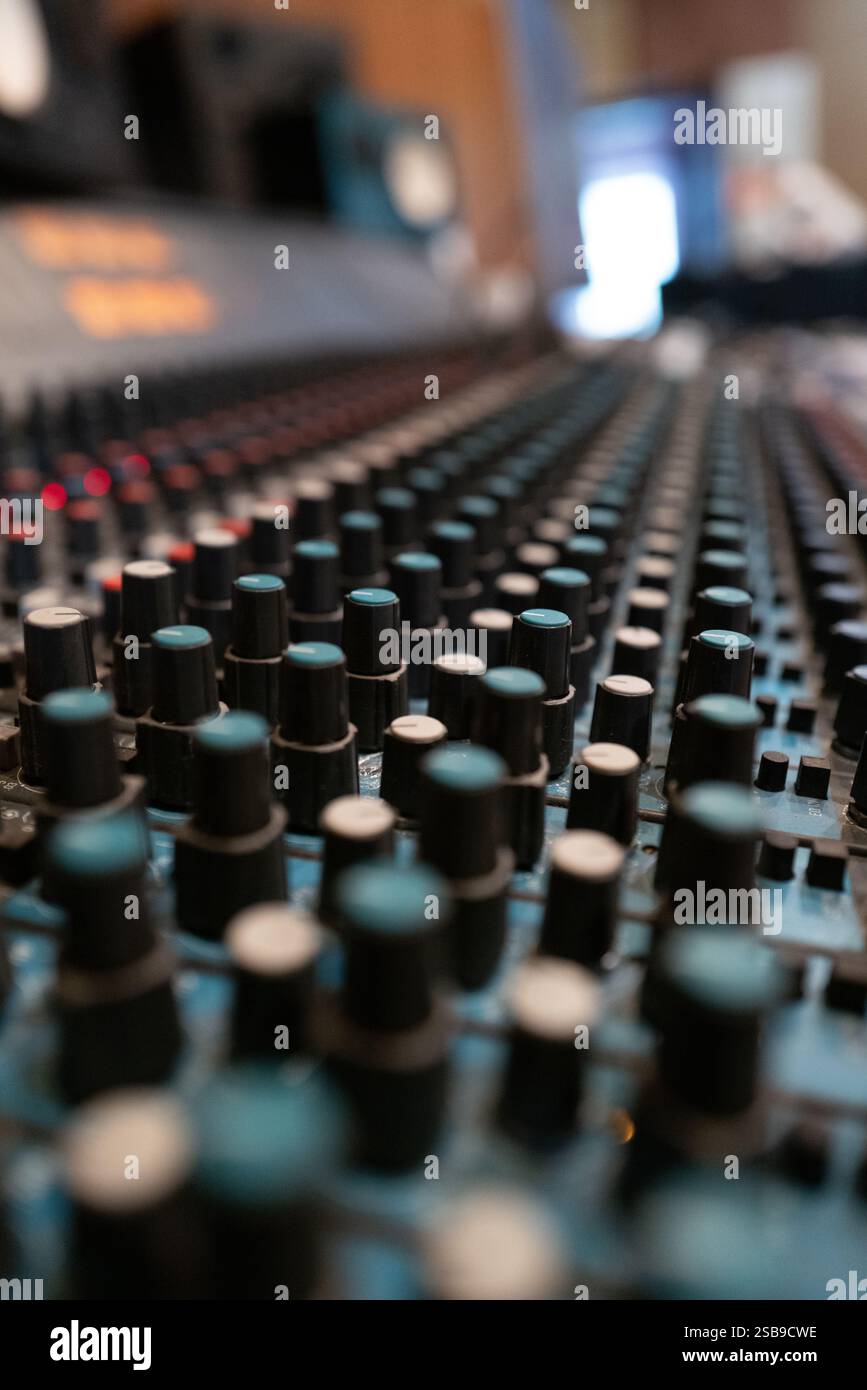 This shot features a detailed view of an audio mixing console ...