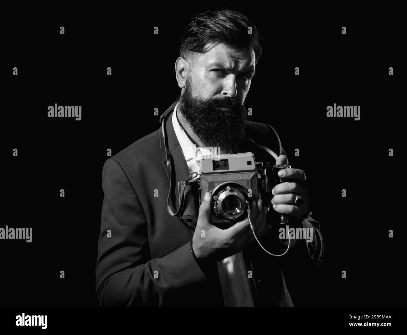 Young man using a professional old camera. Portrait of serious man ...