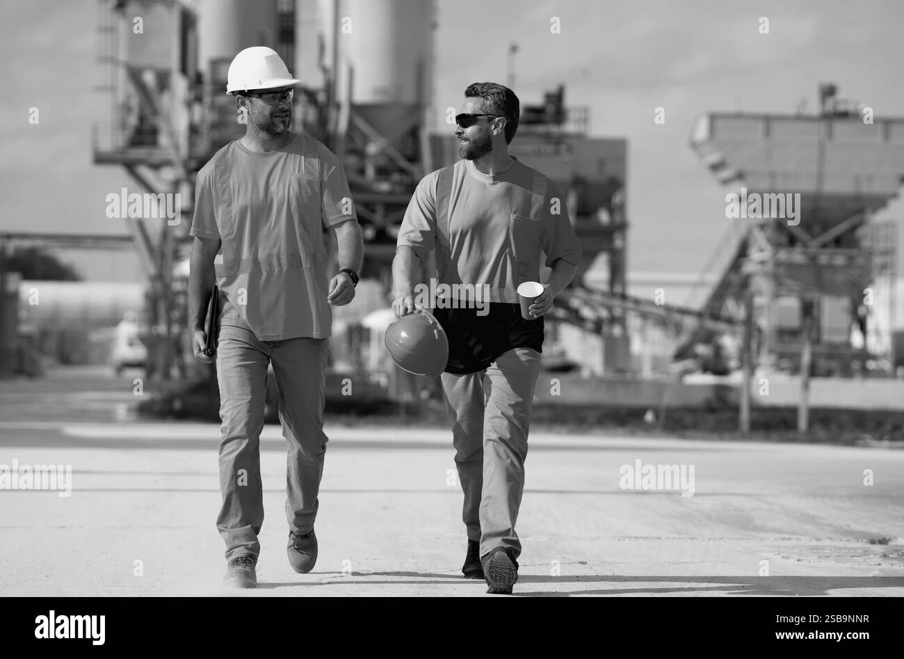Industrial workers outdoors. Engineers in safety uniform and helmet on ...