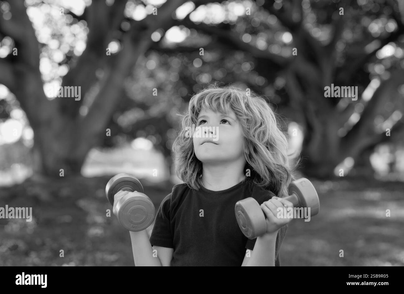 Kids sport training in summer park outdoor. Kid boy working out with ...