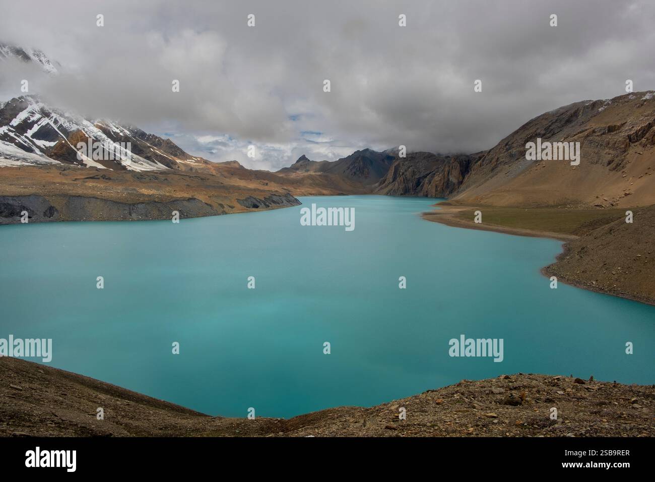 Tilicho Lake, located in the Himalayas of Nepal, is surrounded by grey ...