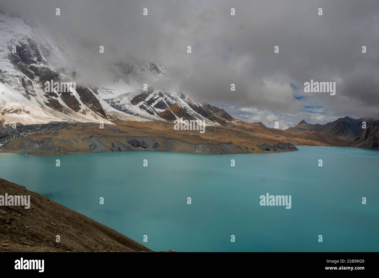Tilicho Lake, located in the Himalayas of Nepal, is surrounded by grey ...