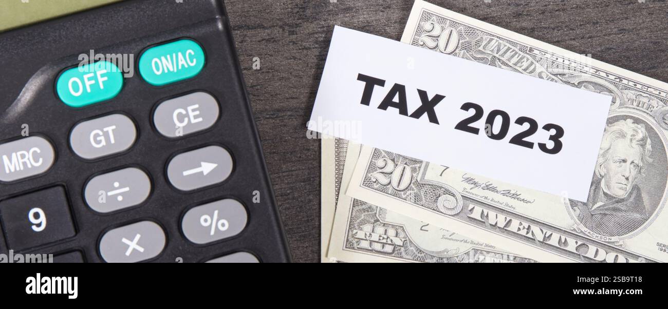 Calculator, inscription tax 2023 and dollar banknotes. Calculating and ...