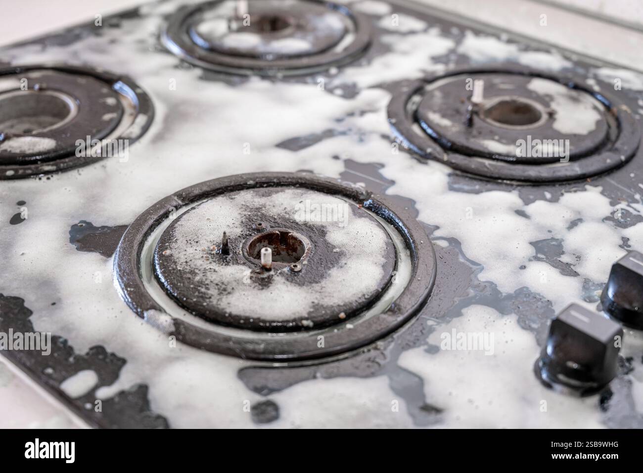 Cleaning a gas stove with kitchen utensils, household concepts, or ...