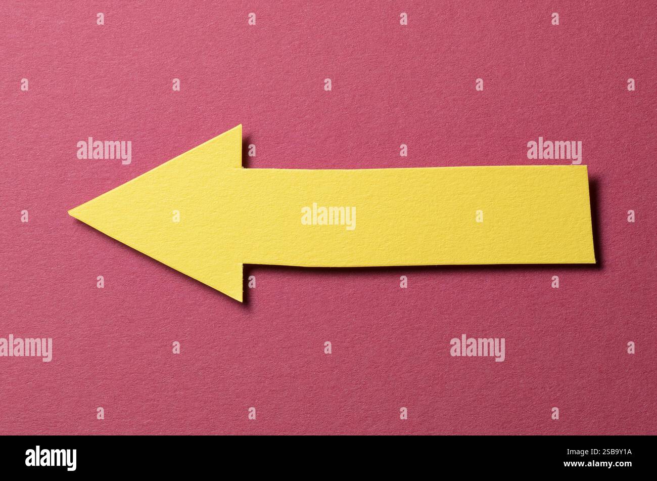 Yellow cut out blank paper cardboard arrow direction sign with copy ...