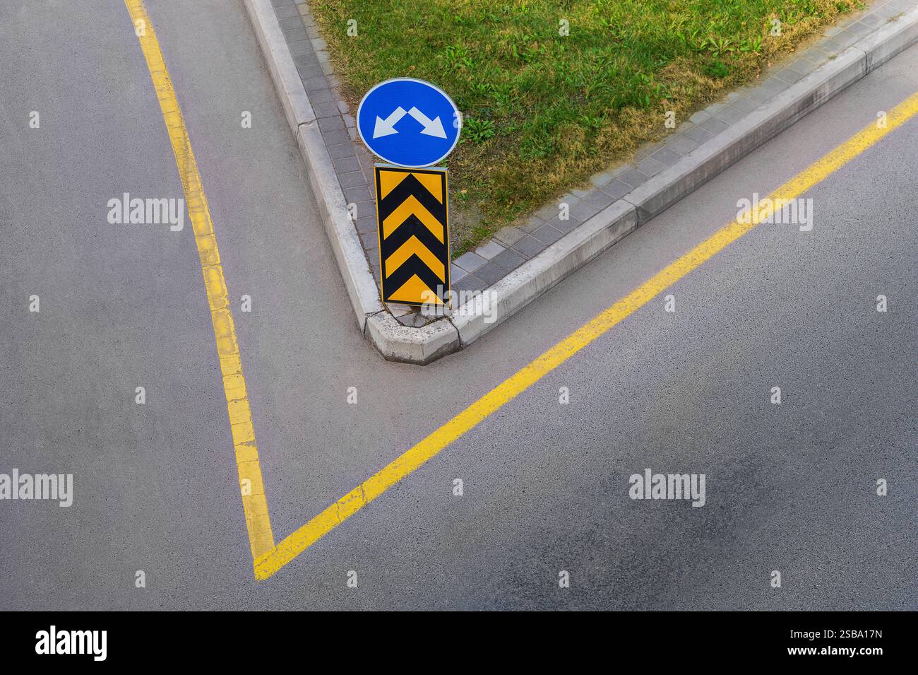 A road fork with road signs: warning blue and orange-black stripes and ...