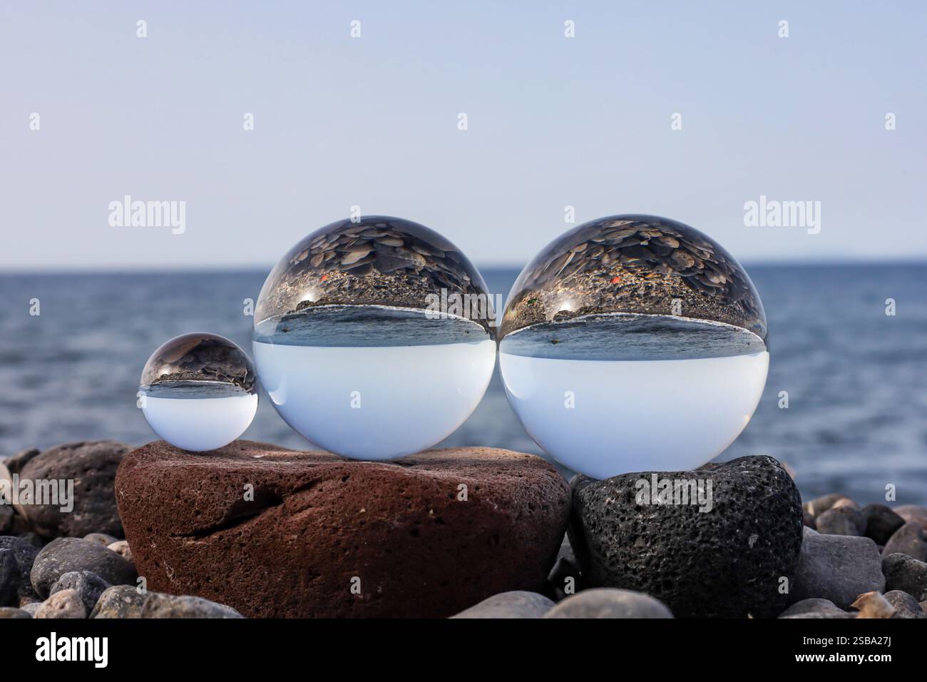 Three Crystal balls, glass spheres, two large and one smaller, resting ...