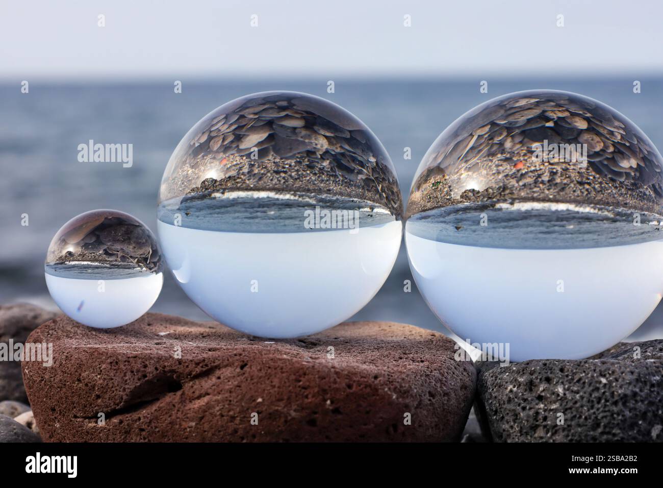 Three Crystal balls, glass spheres, two large and one smaller, resting ...