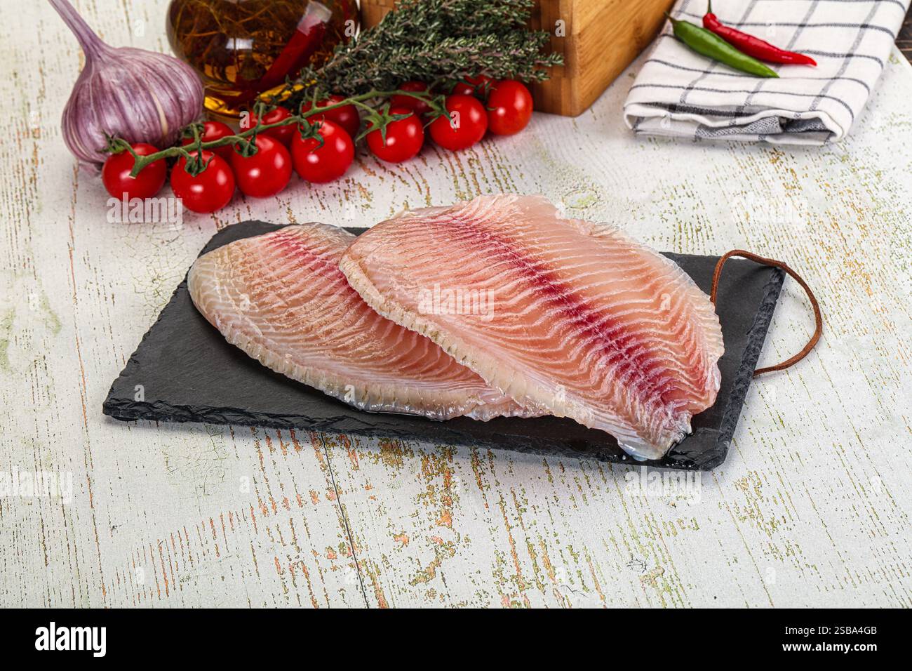 Raw Tilapia fish fillet slice uncooked Stock Photo - Alamy