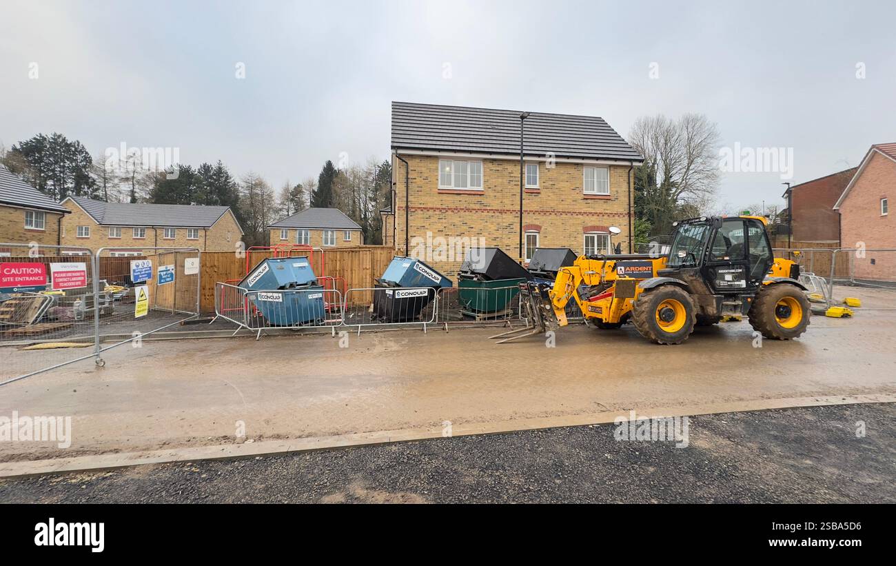A muddy construction site with new houses, several blue and green ...