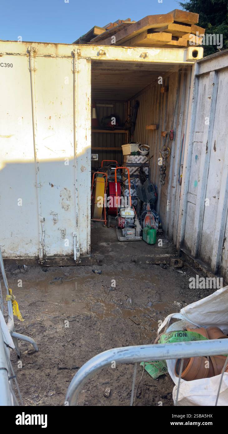 A white shipping container, partially open, reveals various ...