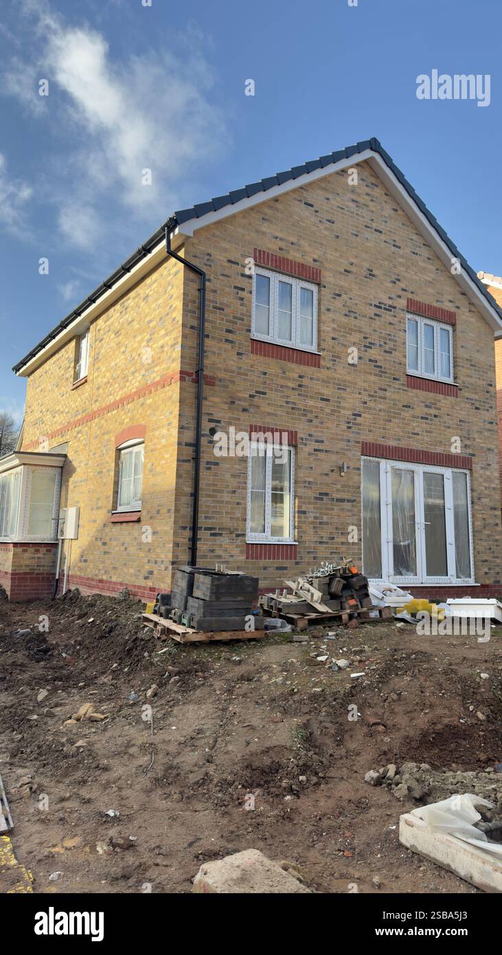 Newly constructed two-story brick house under a partly cloudy sky ...