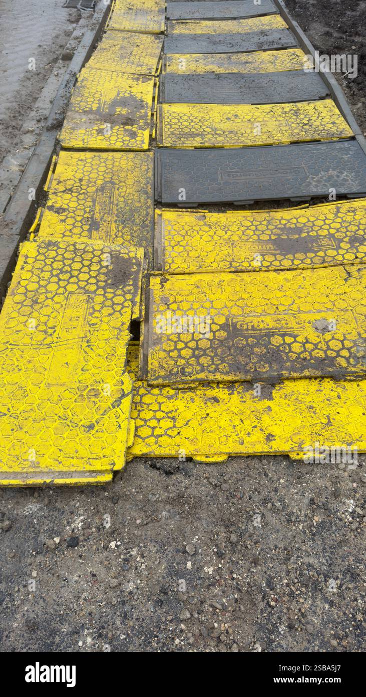 Overlapping yellow and gray rectangular pavement protection plates ...