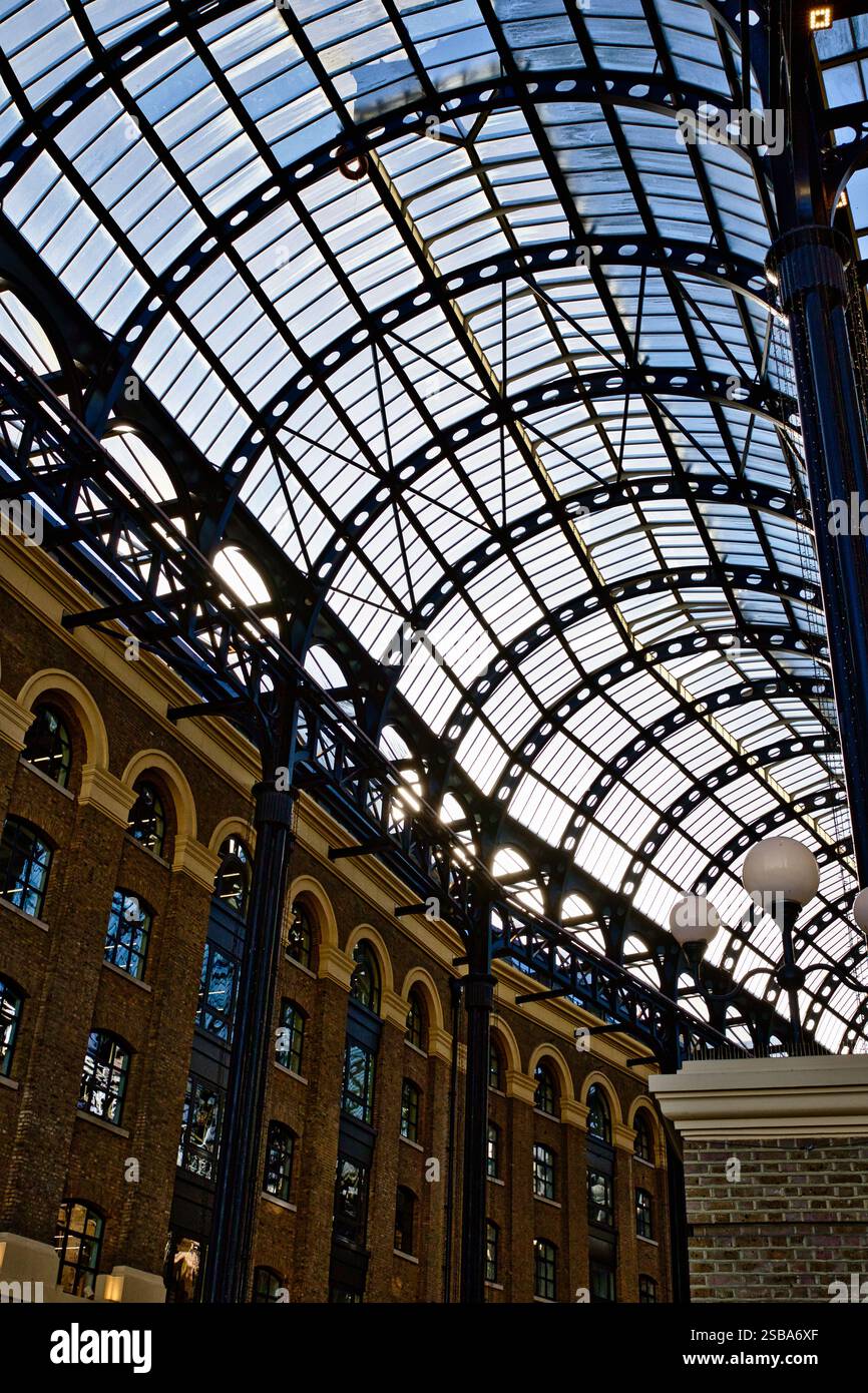 A low-angle view showcases a glass and metal arched roof structure over ...