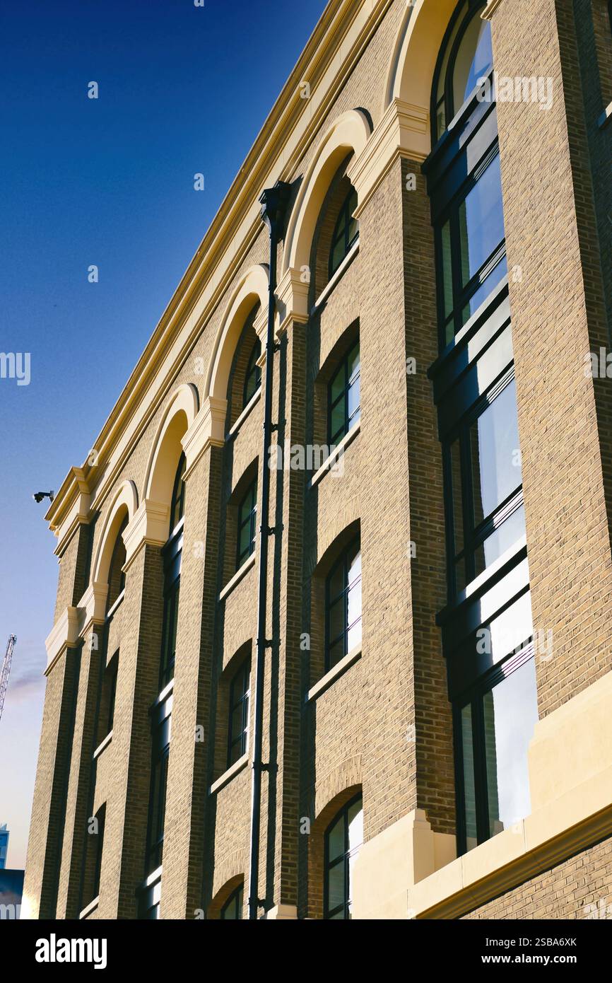 A low-angle view of a multi-story brick building with arched windows ...