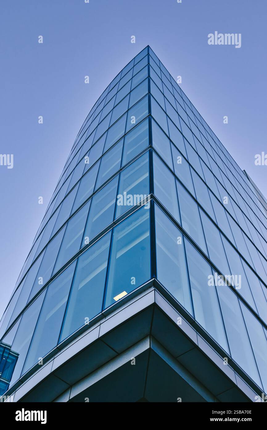 Low-angle view of a modern glass skyscraper corner, showcasing its grid ...