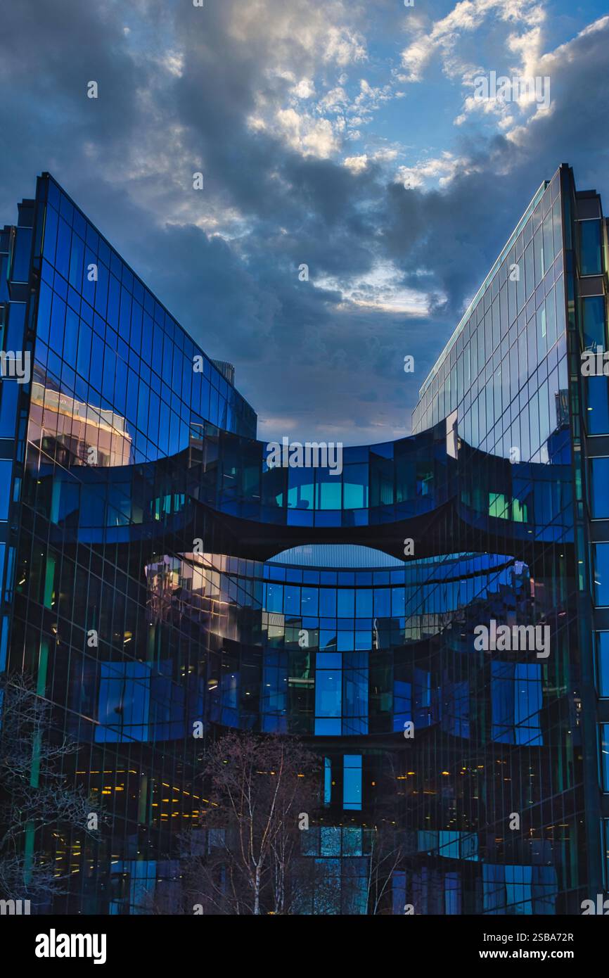 A contemporary glass-fronted building with a curved, bridge-like ...