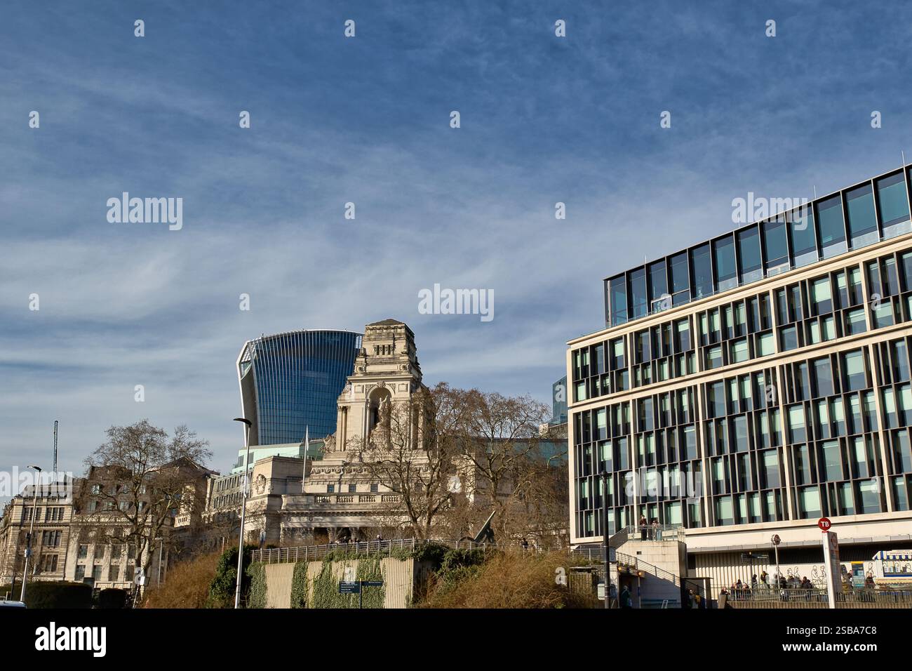 Modern and historic London buildings under a partly cloudy blue sky. A ...