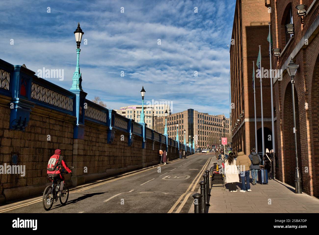 A sunny day scene on a city street, featuring a cyclist, pedestrians ...