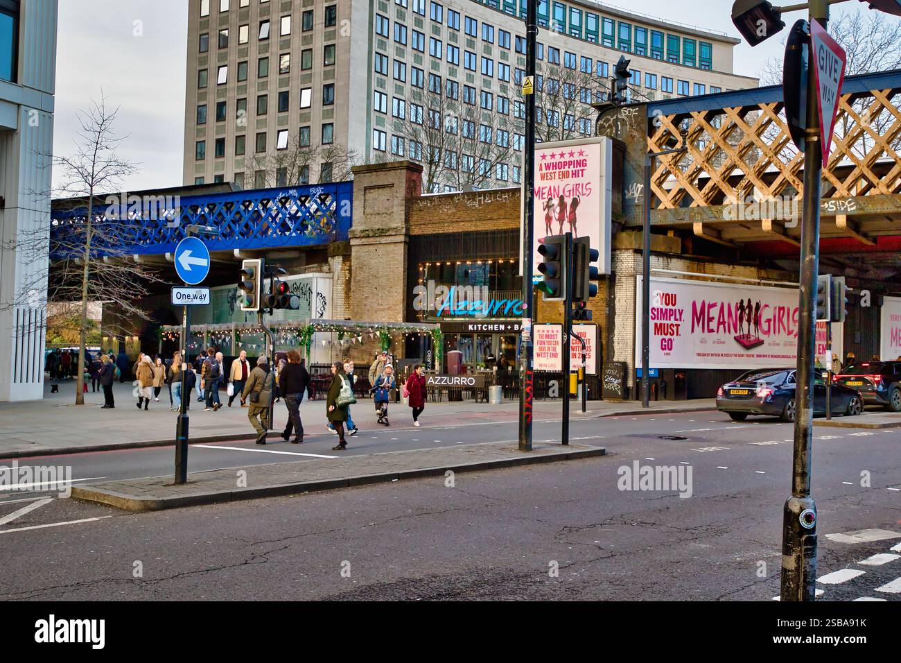 A city street scene featuring pedestrians crossing at a crosswalk ...