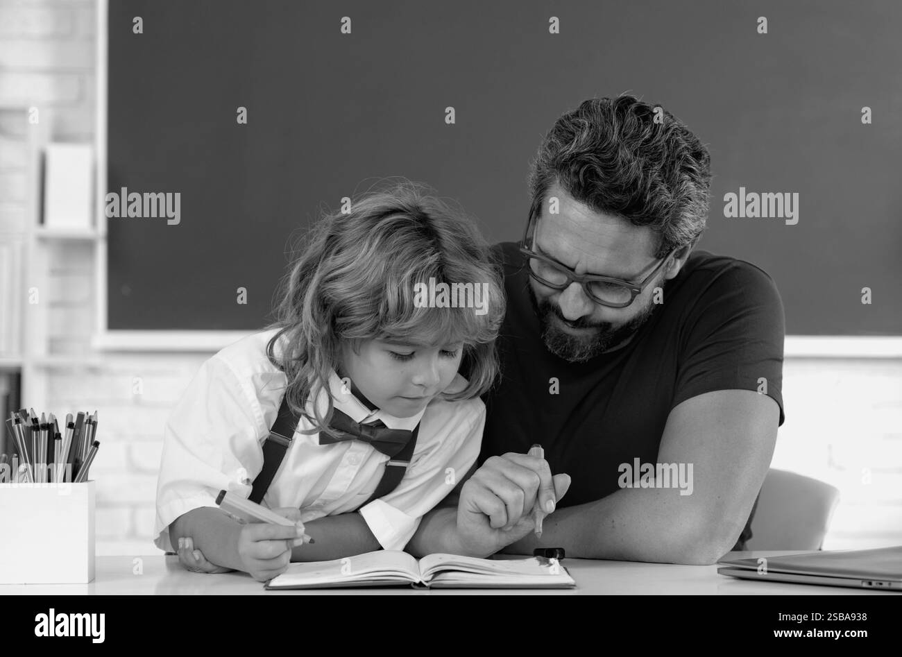 Teacher helping child student pupil from elementary school in classroom ...