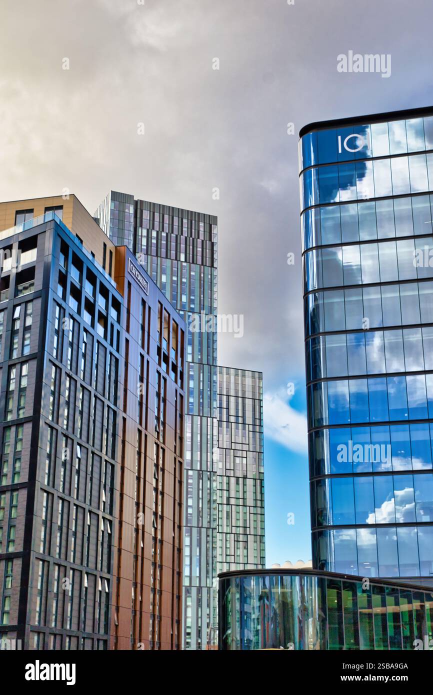 Modern city buildings under a cloudy sky. Three tall buildings with ...