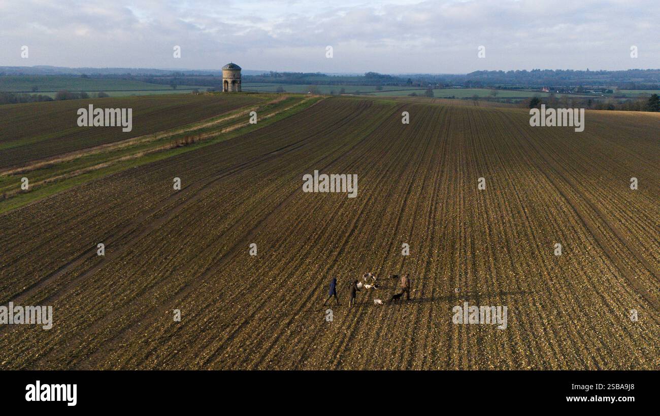 People walk their dogs across fields in the village of Chesterton in ...