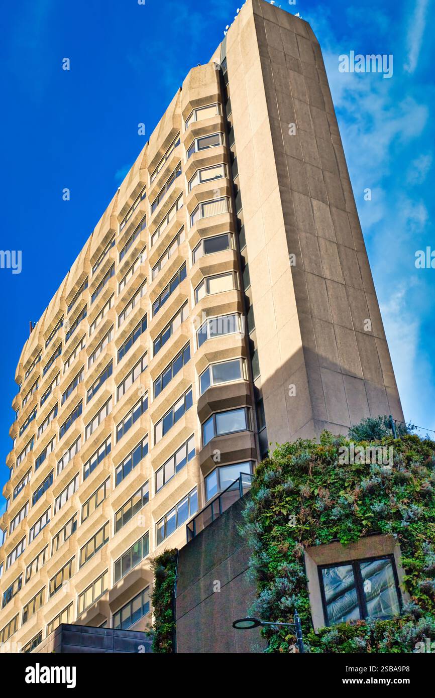 A beige high-rise building with numerous windows, set against a vibrant ...