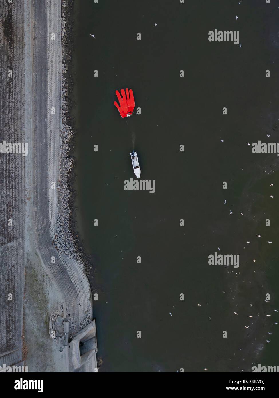 Aerial view of boat pulling red hand. Symbol. Students protest against ...