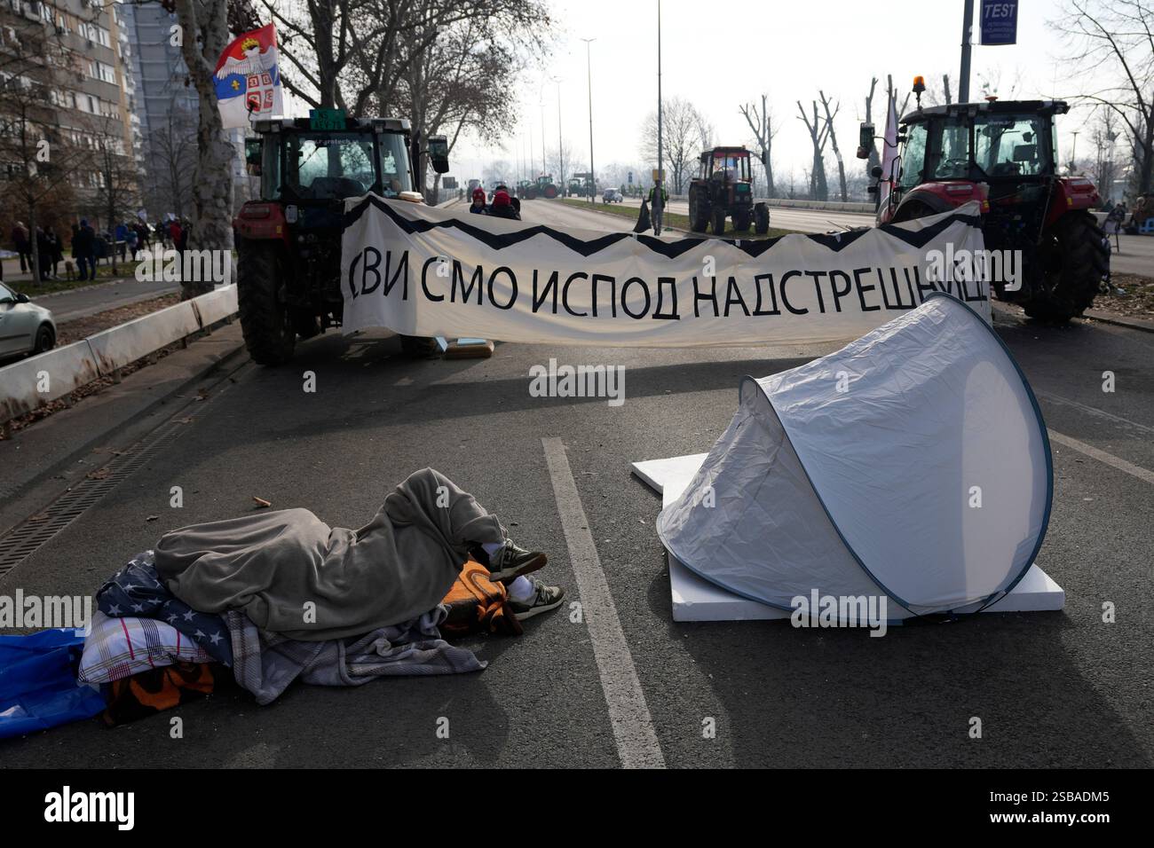 A man sleeps on the road during an ongoing protest over the collapse of ...