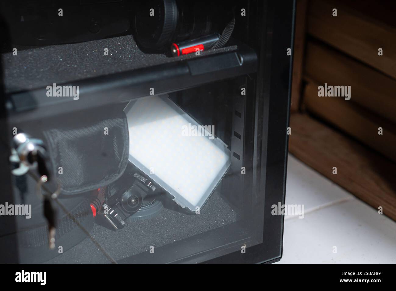 A close-up view of a camera storage cabinet featuring a camera, a light ...