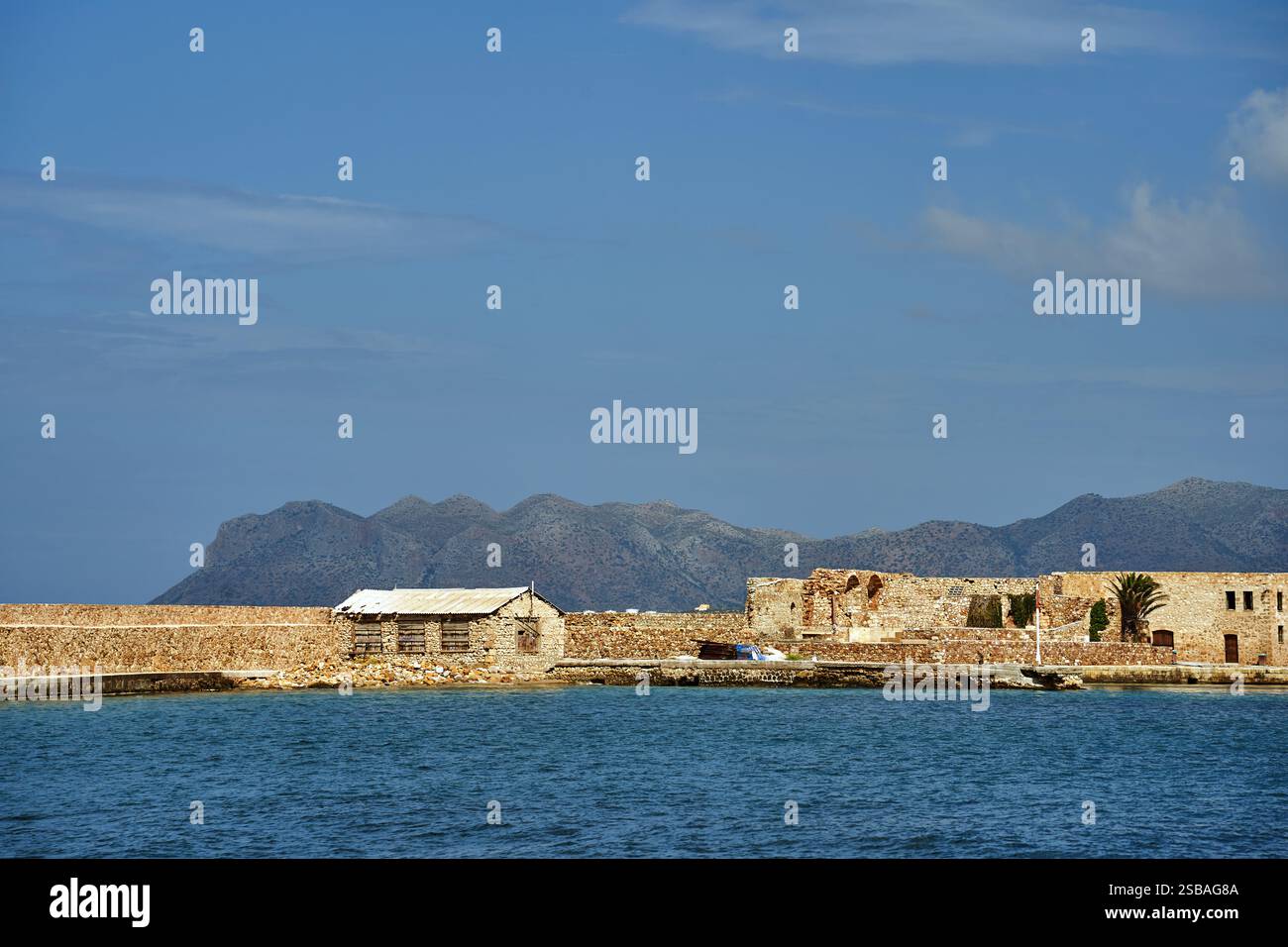Stone breakwater and medieval buildings in the historic port of Chania ...