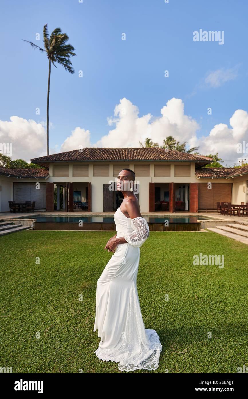 Ambiguous gender fluid person in white bridal dress at villa garden ...