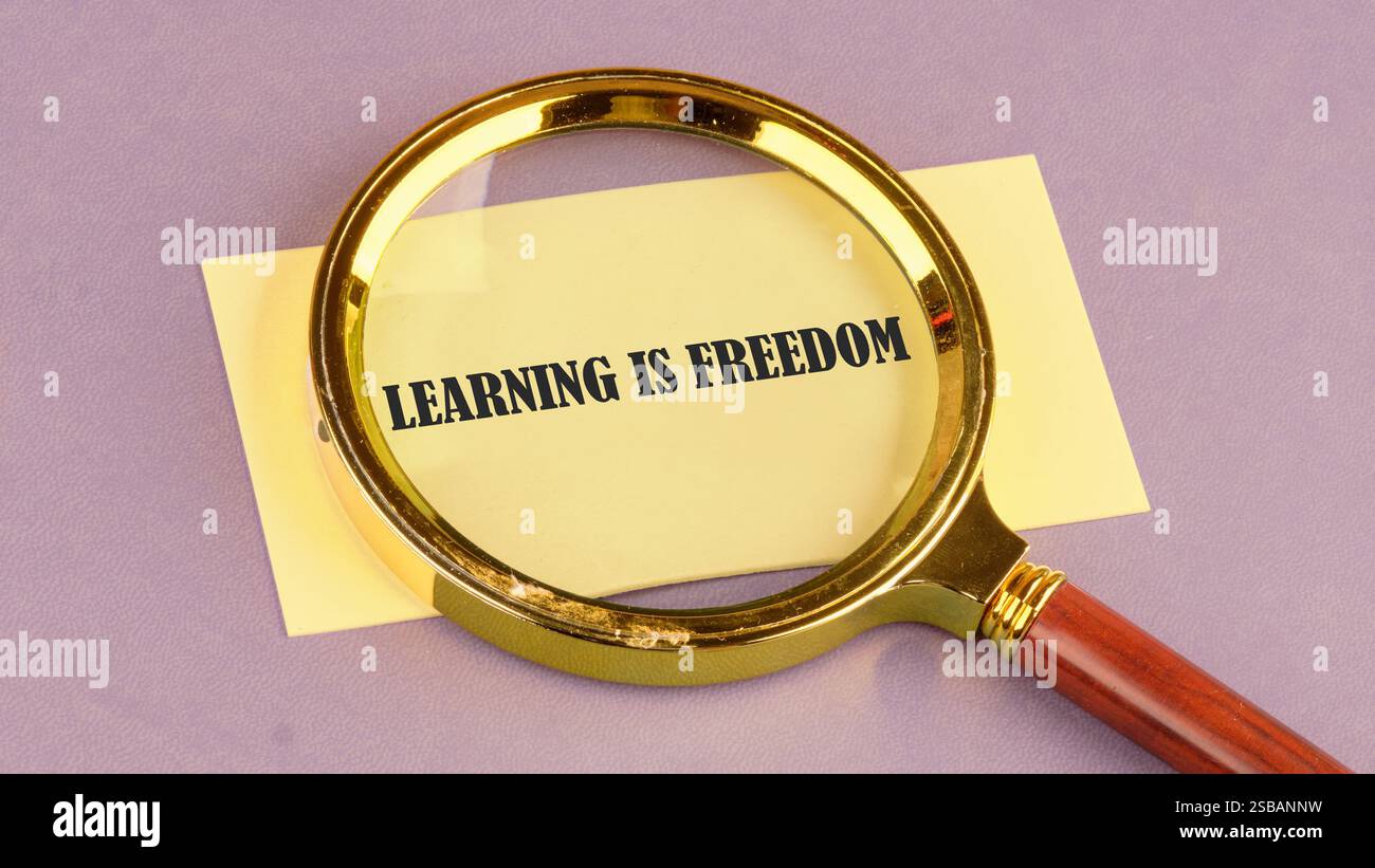 A magnifying glass focuses on a note stating that learning is freedom ...