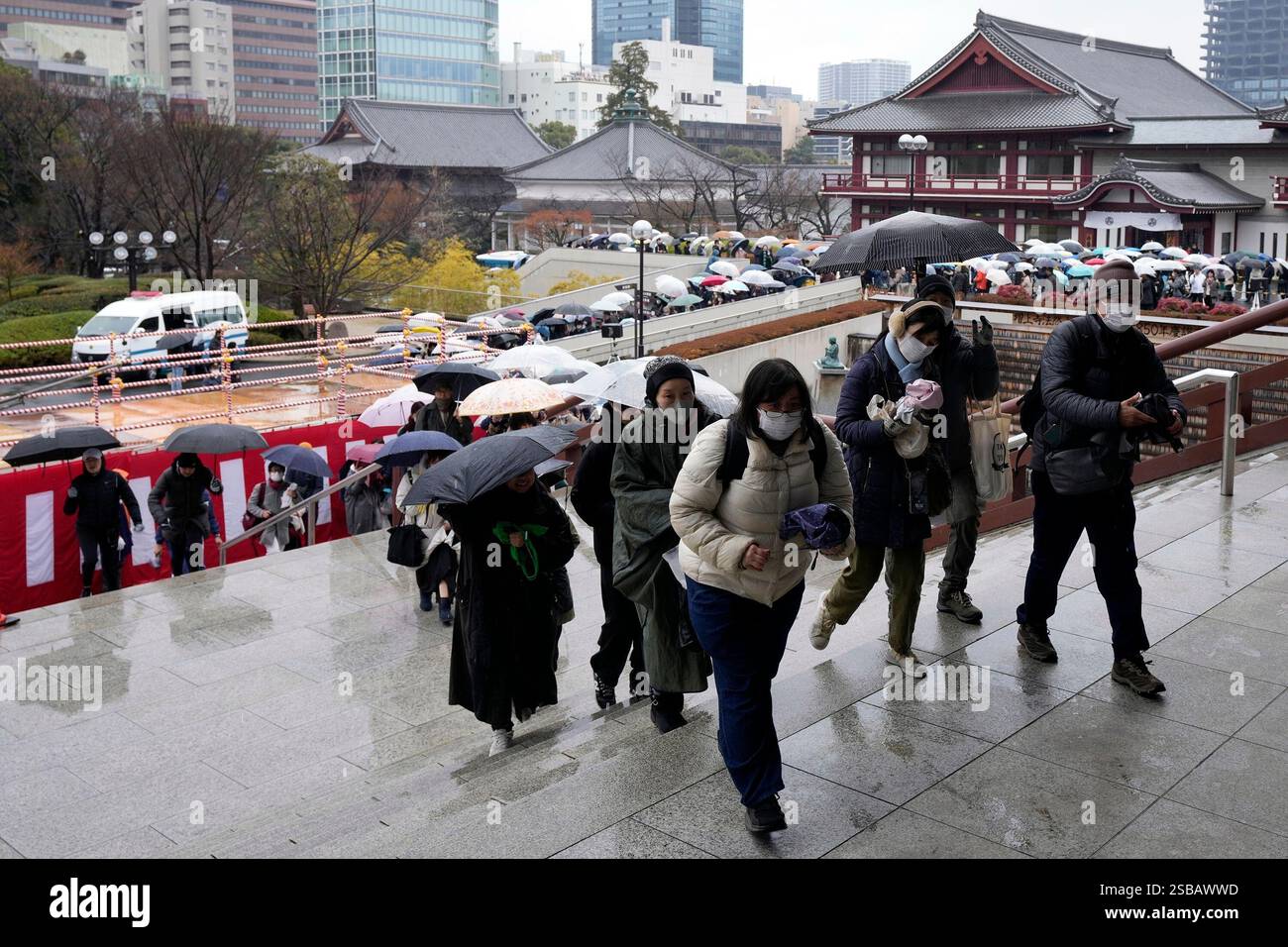 People arrive in the rain to attend the annual "Mame-maki," in the hope ...