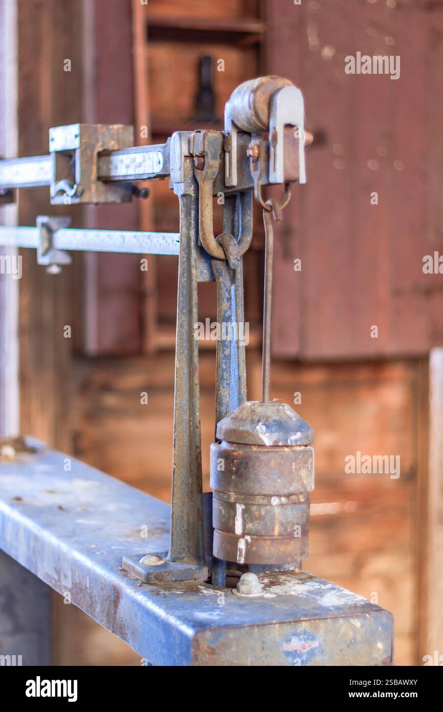 A rusty scale with a weight on it. The scale is old and has a worn ...