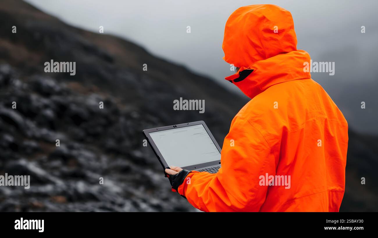 Field technician using a shock-resistant laptop to capture data in a ...
