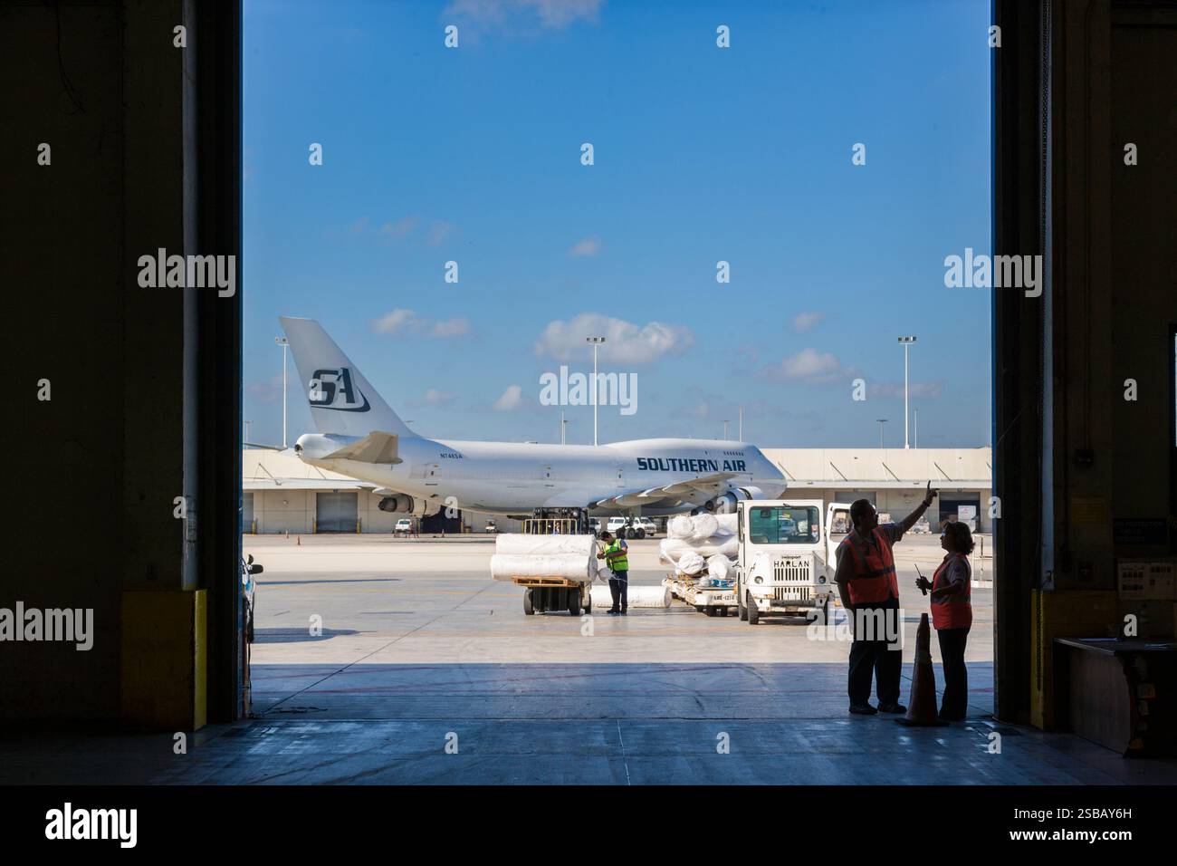 Ground crew coordinates cargo loading as a Southern Air Boeing 747 ...