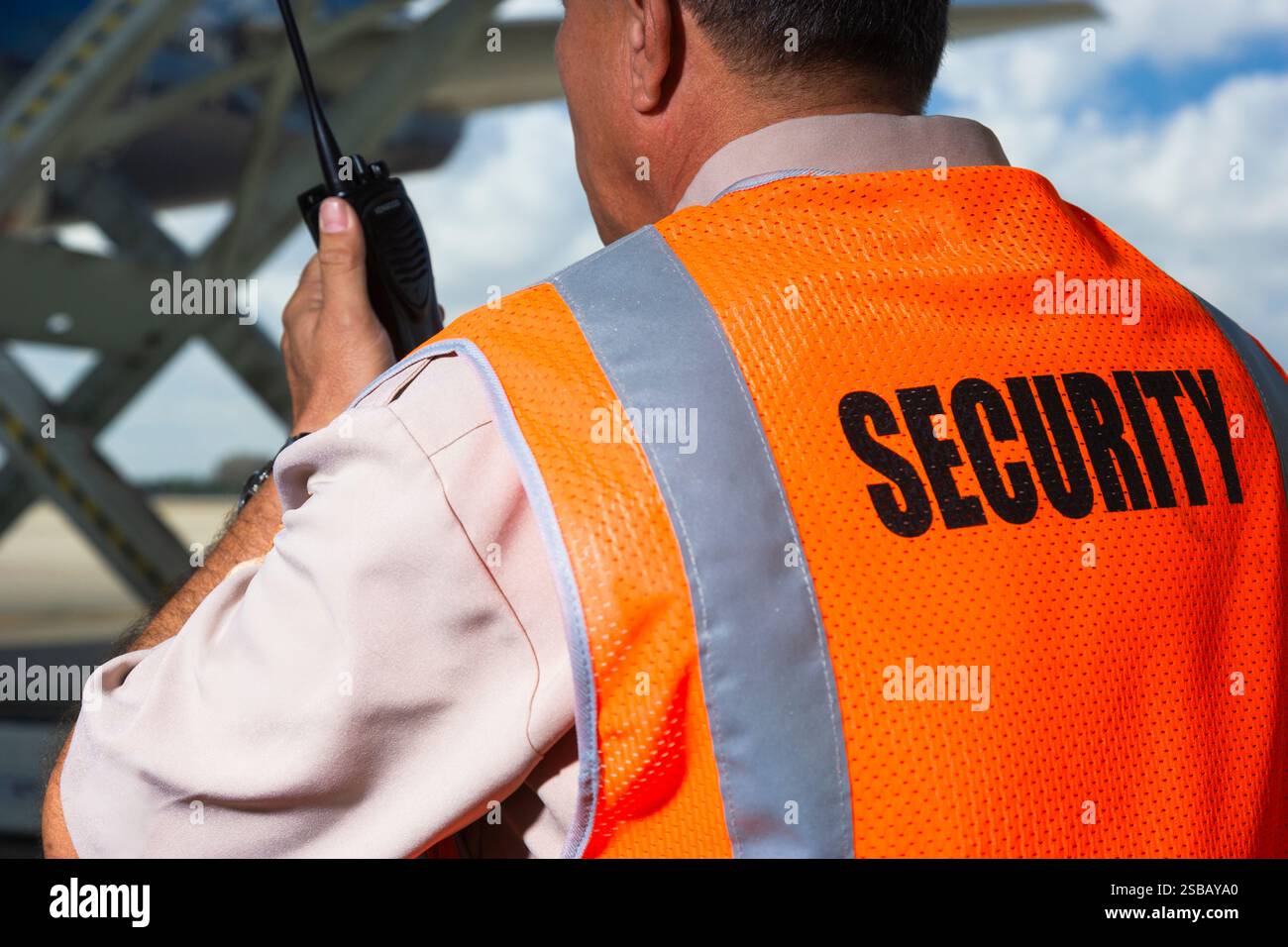A close-up of an airport security personnel wearing a high-visibility ...
