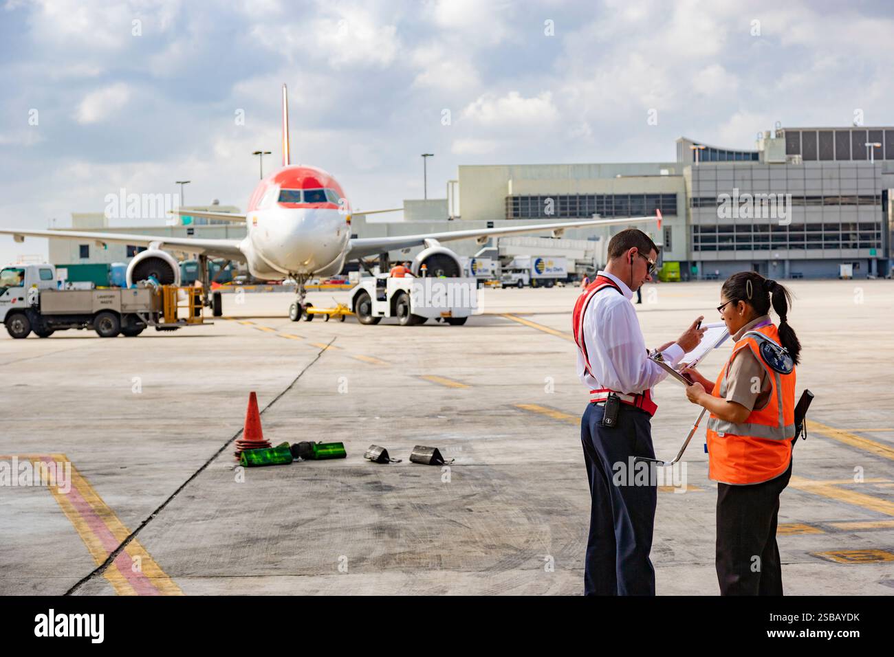 Aviation ground crew personnel at Miami International Airport conducting pre-flight coordination ...