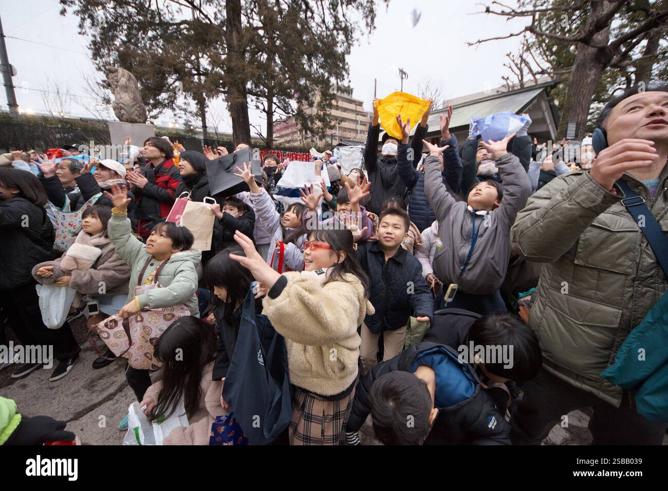 People try to catch bags containing lucky beans during the bean ...