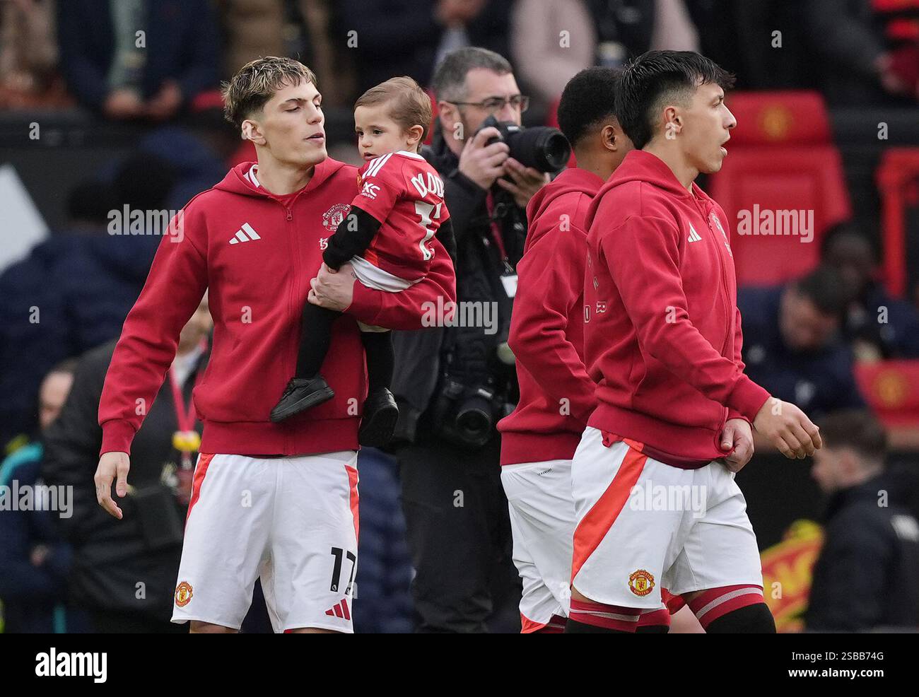 Manchester United's Alejandro Garnacho (left) walks onto the pitch with his son Enzo during the ...