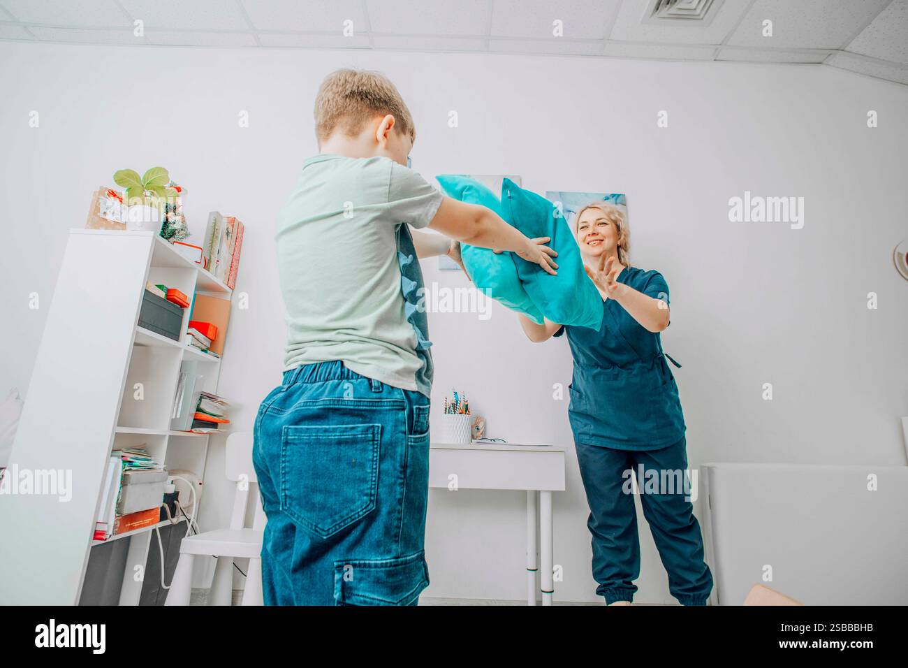 active child standing on a balancing board while engaging in a pillow ...