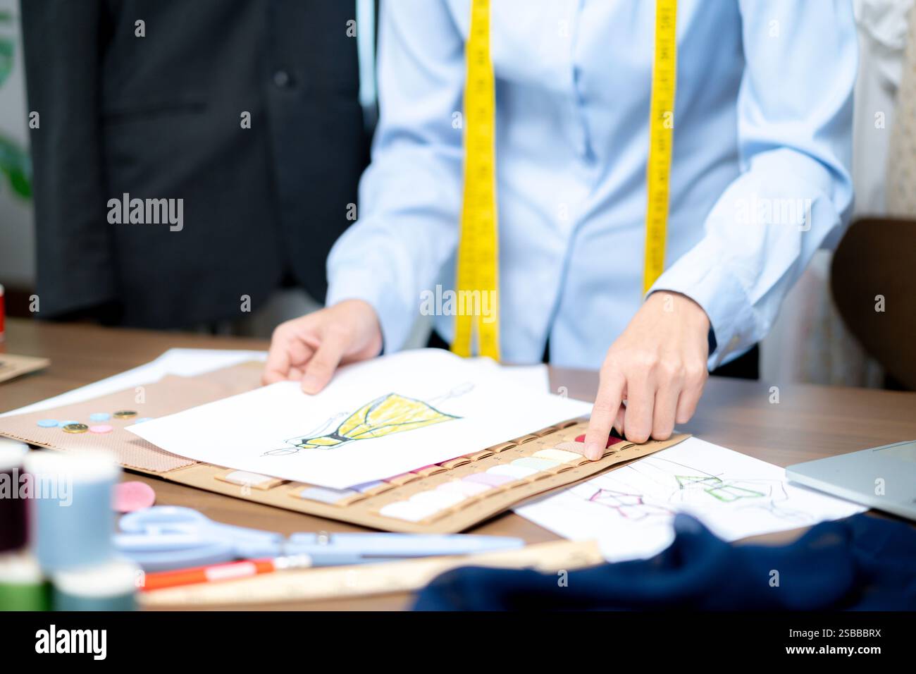 A female designer is creating clothing designs in her studio Stock ...