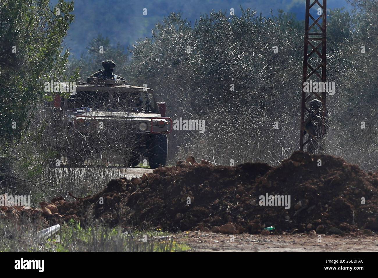 Israeli soldiers take their positions as they block a road leading to ...
