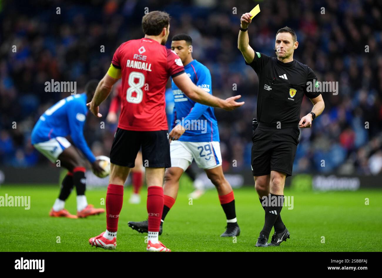 Referee Steven McLean shows a yellow card to Ross County's Connor ...