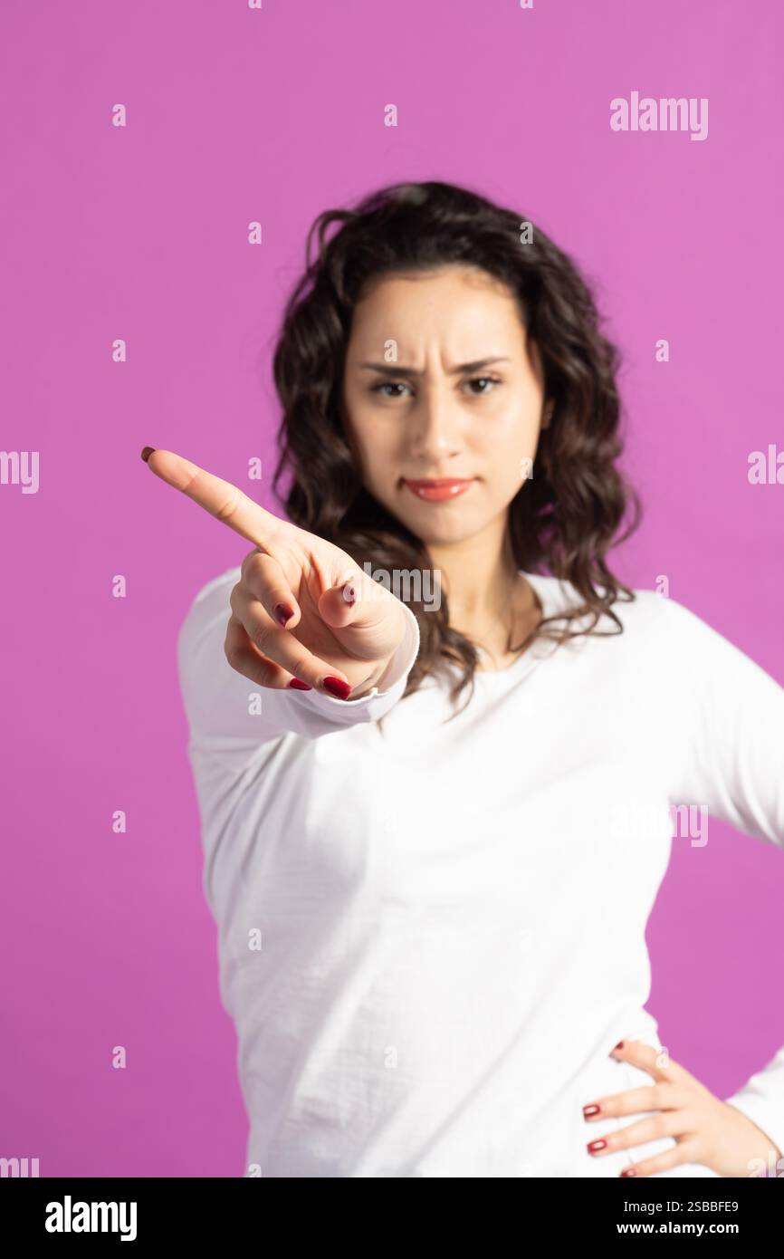 Lifestyles concept. Woman pointing finger at camera as sign of stop or ...
