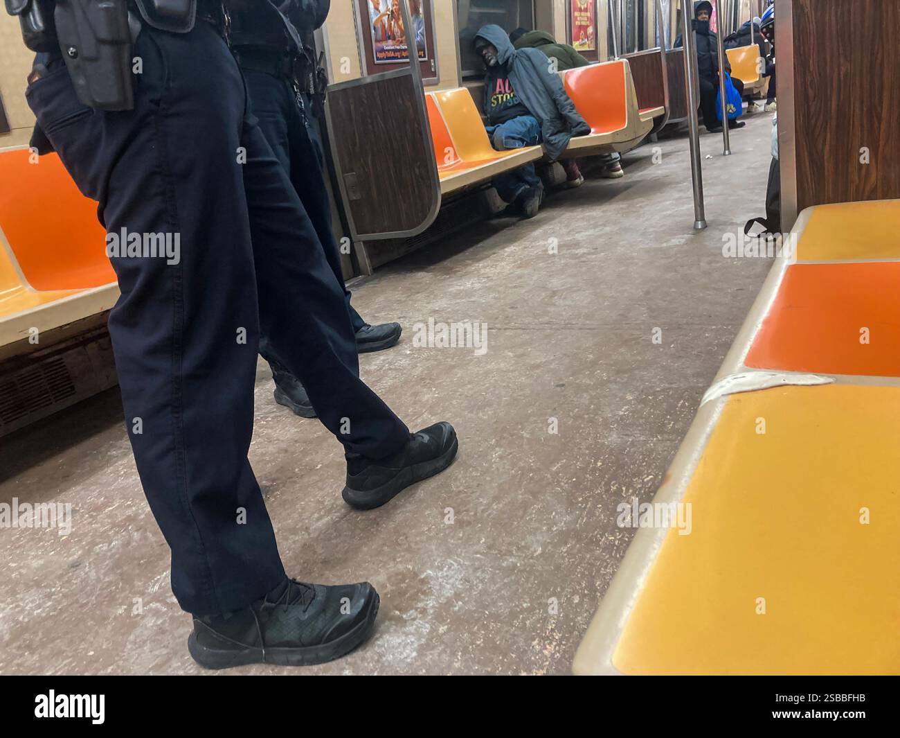 NYPD officers patrol a subway car filled with homeless sleeping in New ...