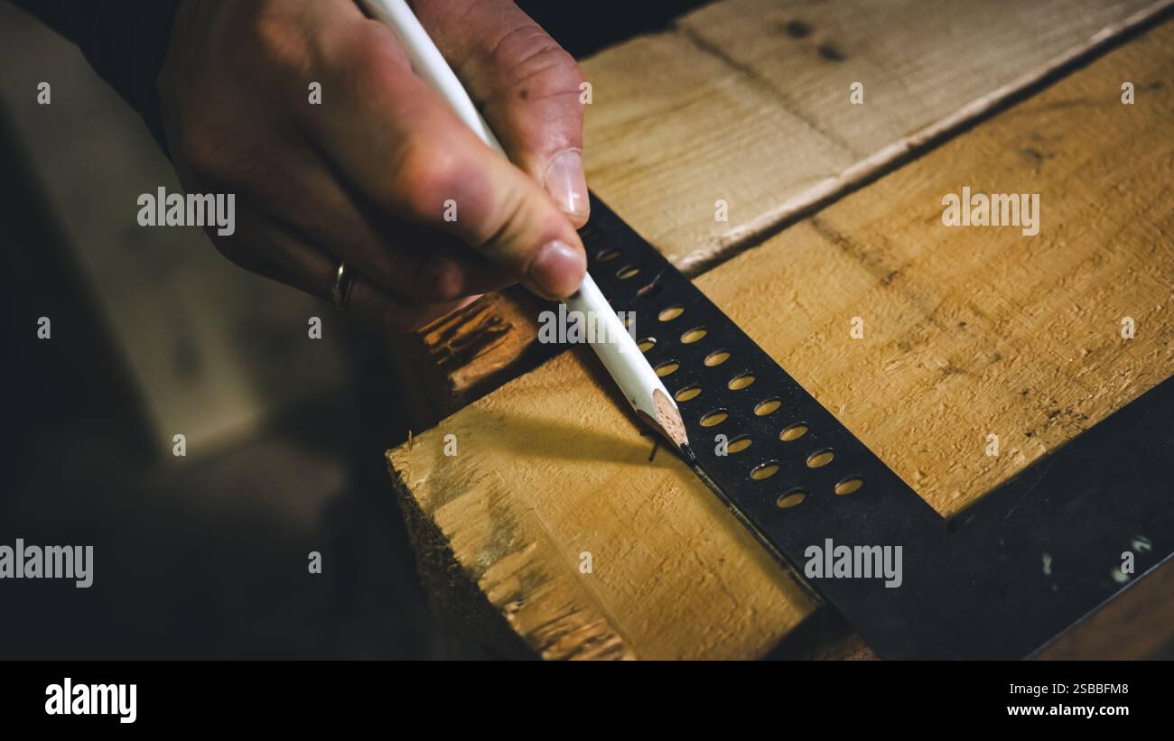 Carpenter draws line on wooden beam with angle Stock Photo - Alamy